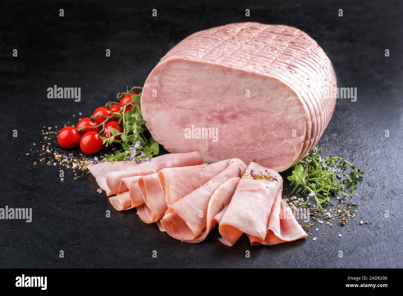 Traditional German boiled ham as piece and sliced decorated with ...