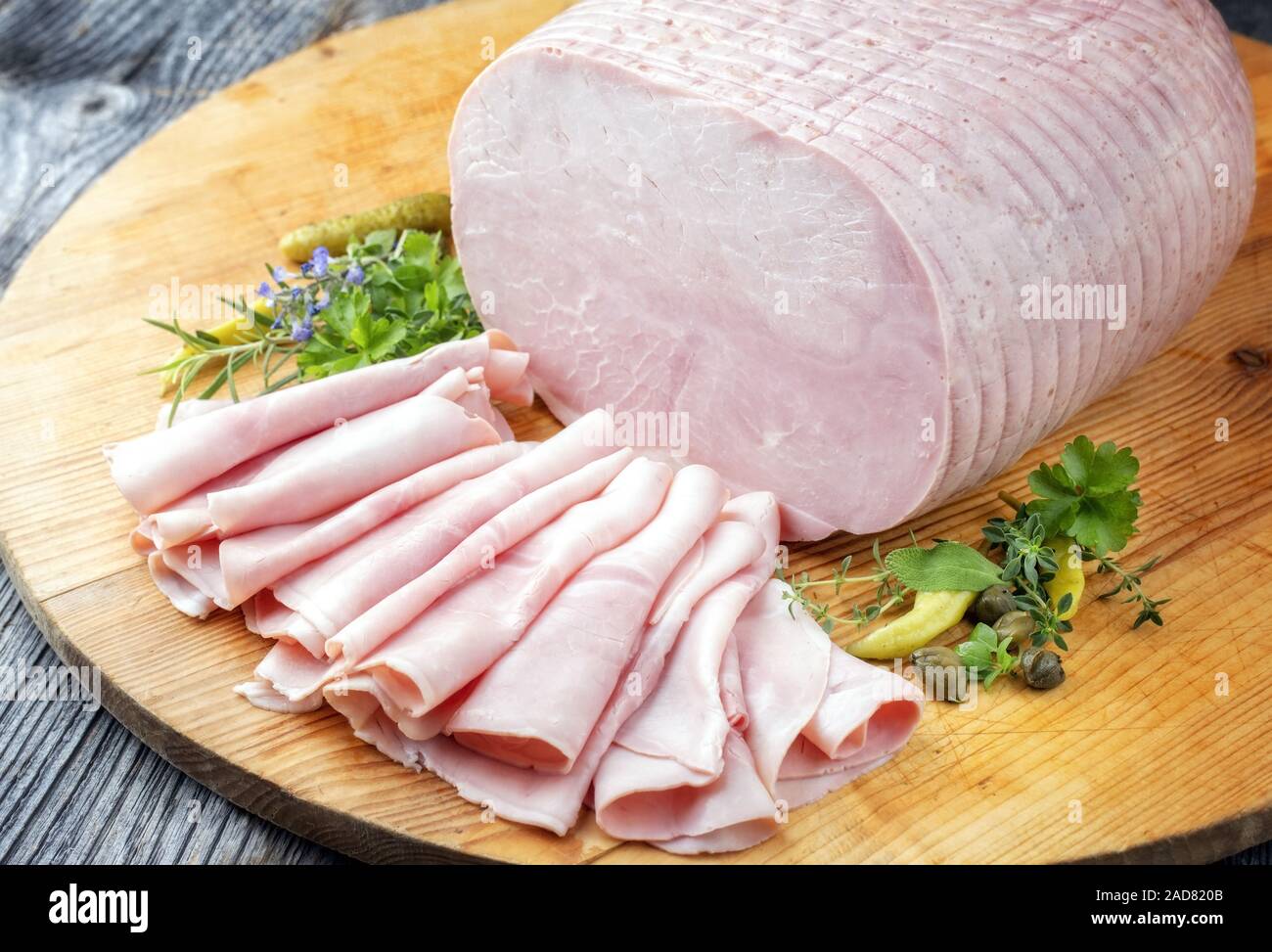 Traditional German boiled ham as piece and sliced decorated with ...