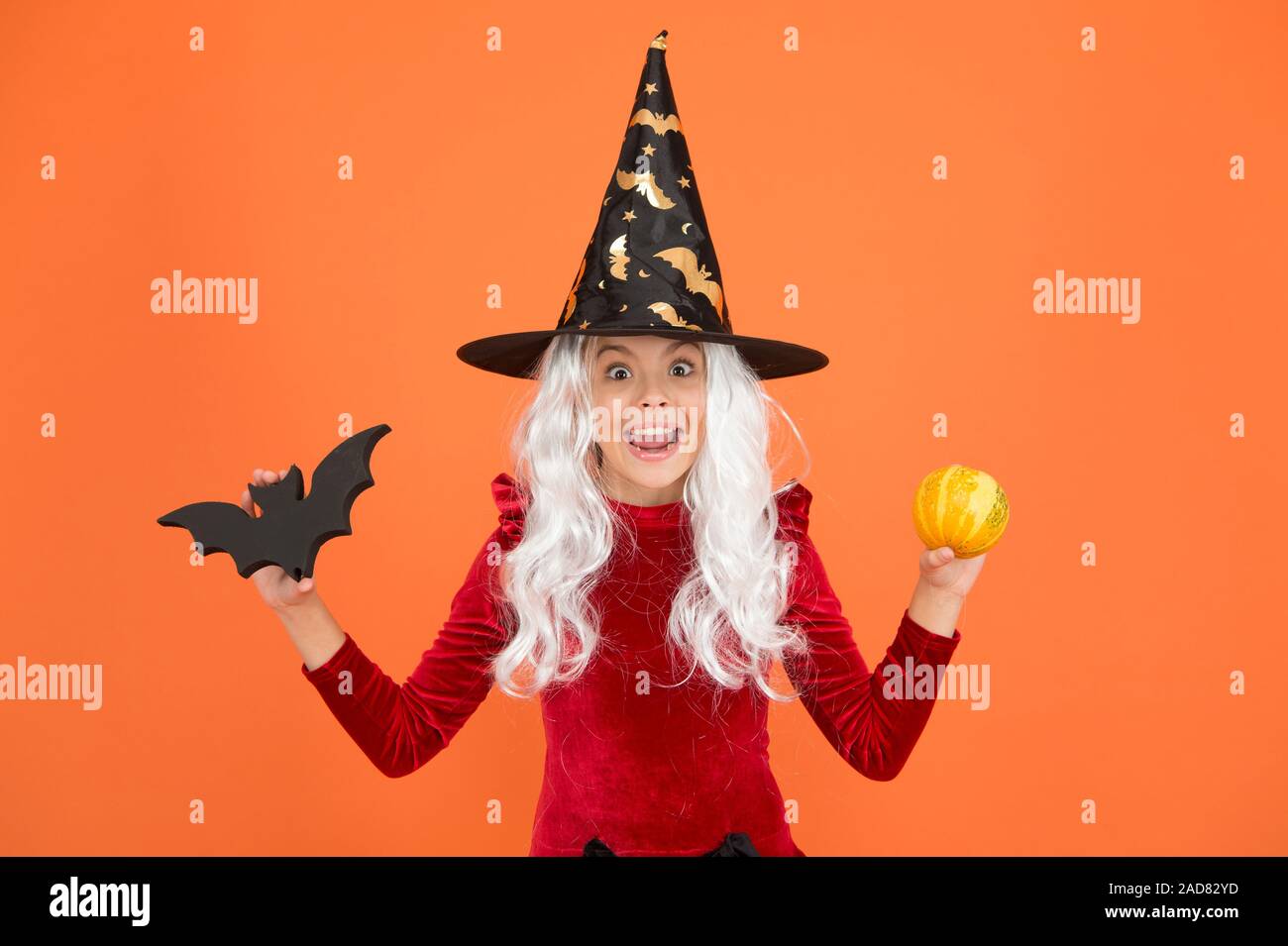 Freakishly wicked Halloween. Little wicked witch child hold bat and ...