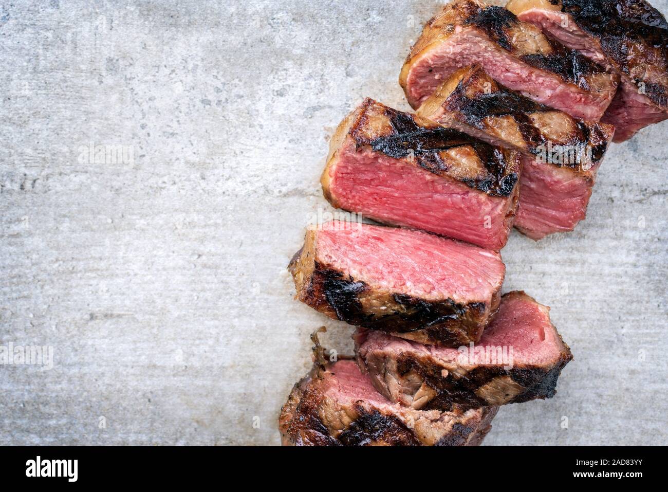 Barbecue wagyu roast beef sliced as top view on a gray board with copy ...