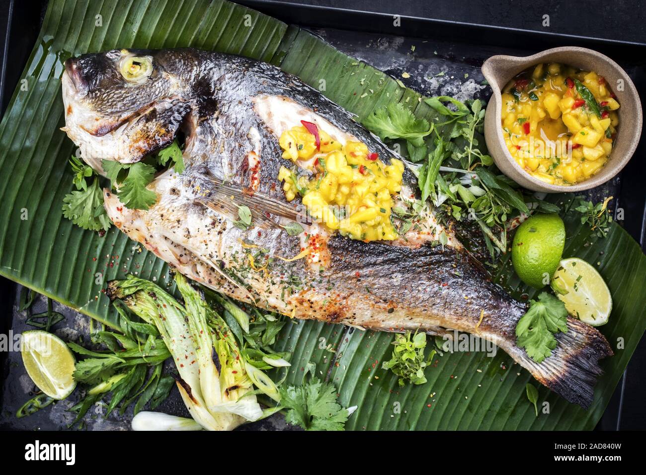 Fresh barbecue gilthead seabream with lettuce and mango chutney as top ...