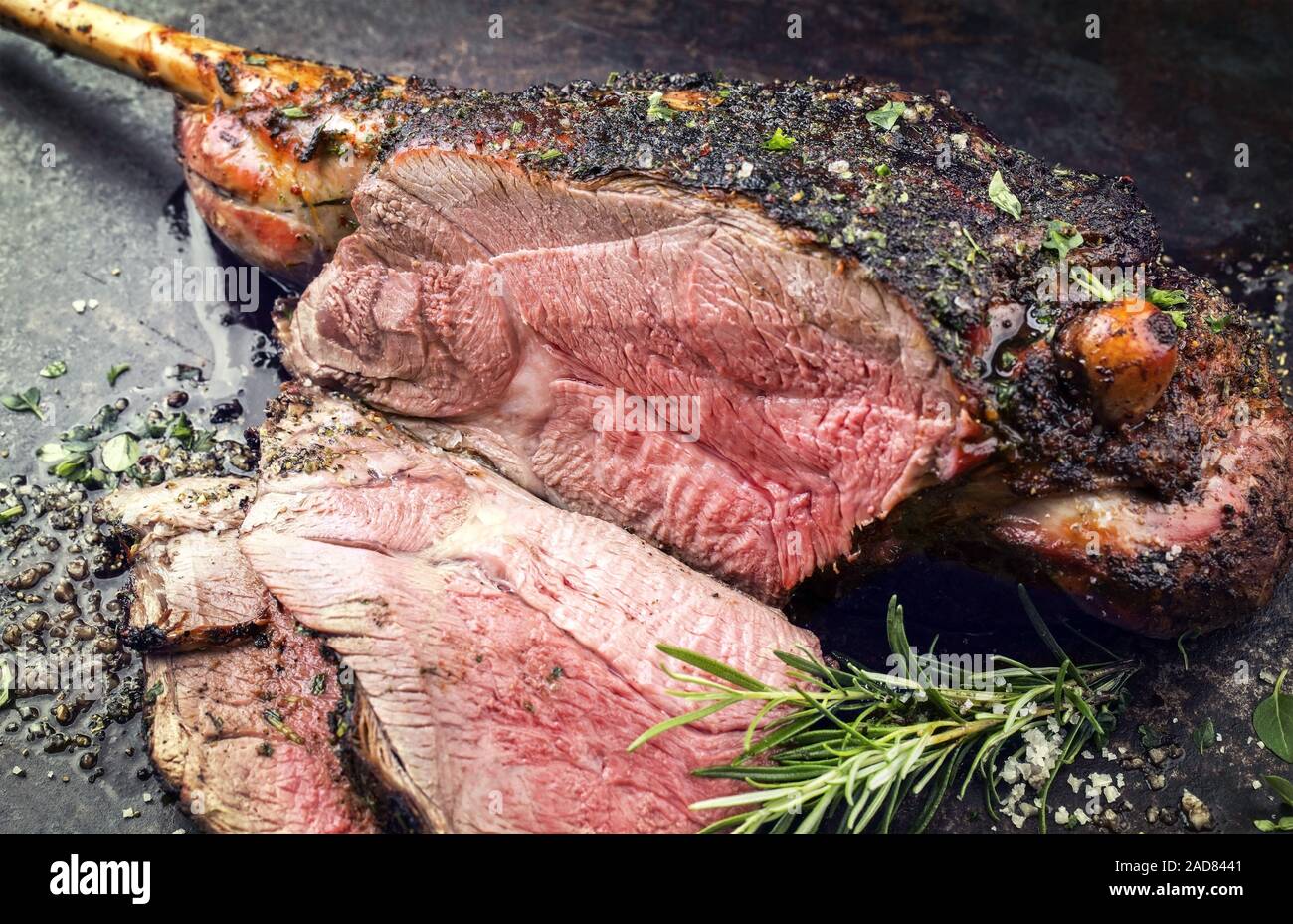 Traditional barbecue leg of lamb with spice and herb as top view on a ...