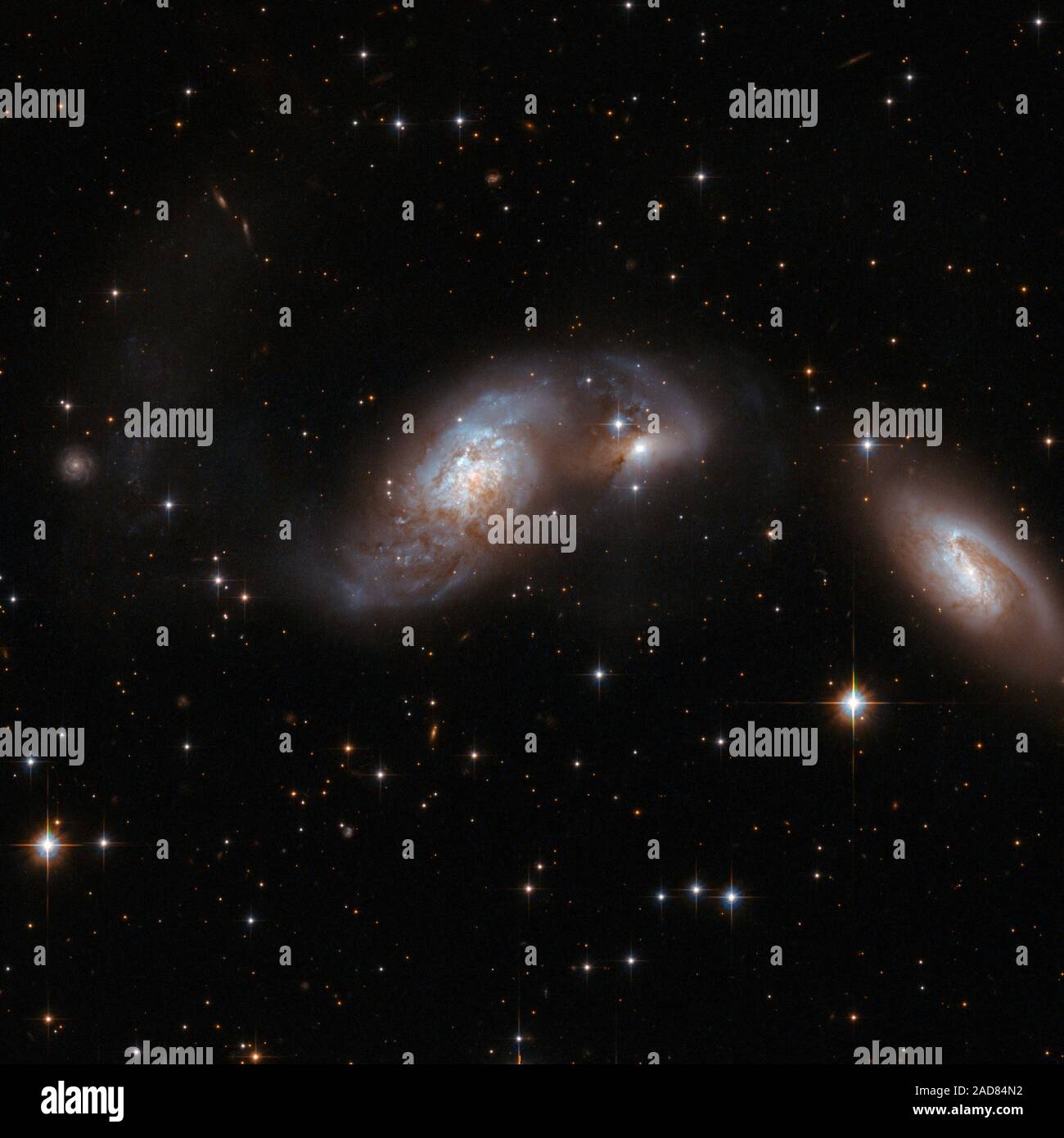 IC 4687 forms a triplet with two other galaxies: IC 4686 to the right ...