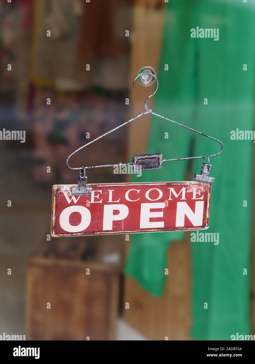 Close-up of Welcome Open sign hanging from a coat hanger at the ...
