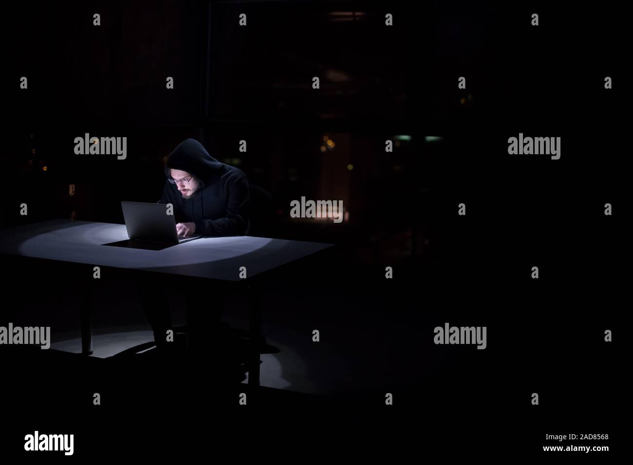 hacker using laptop computer while working in dark office Stock Photo ...