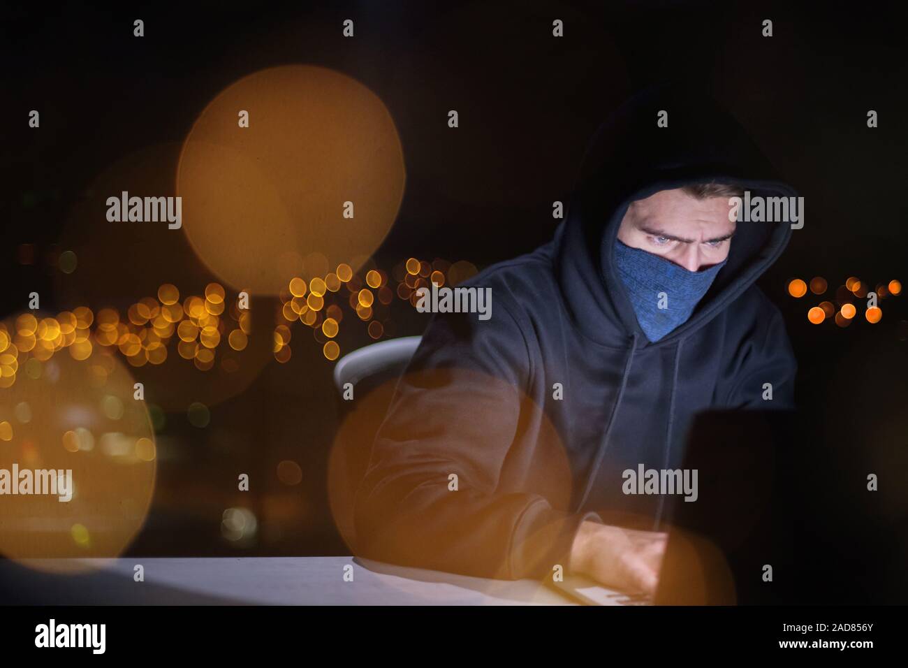 hacker using laptop computer while working in dark office Stock Photo ...