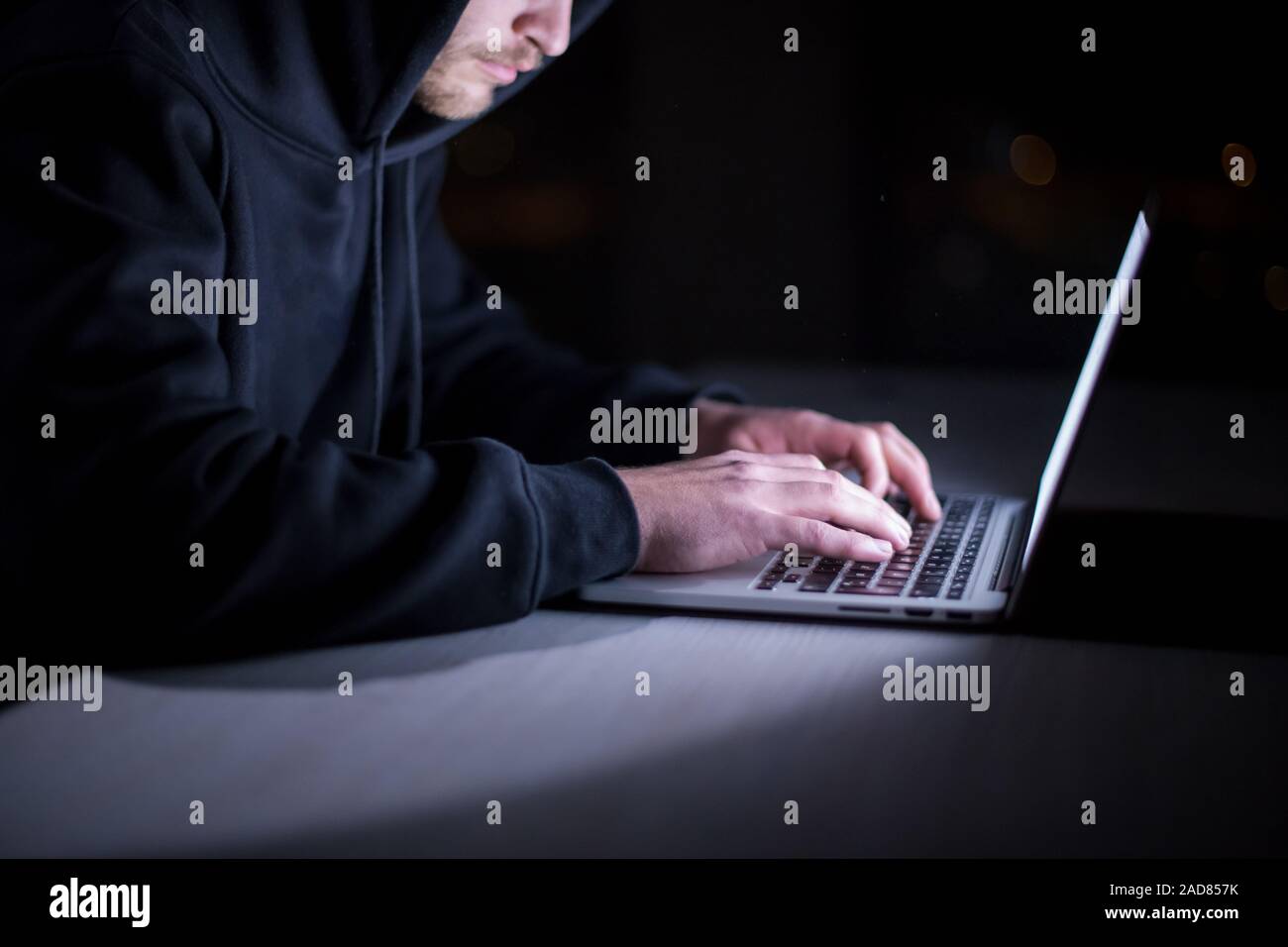 hacker using laptop computer while working in dark office Stock Photo ...