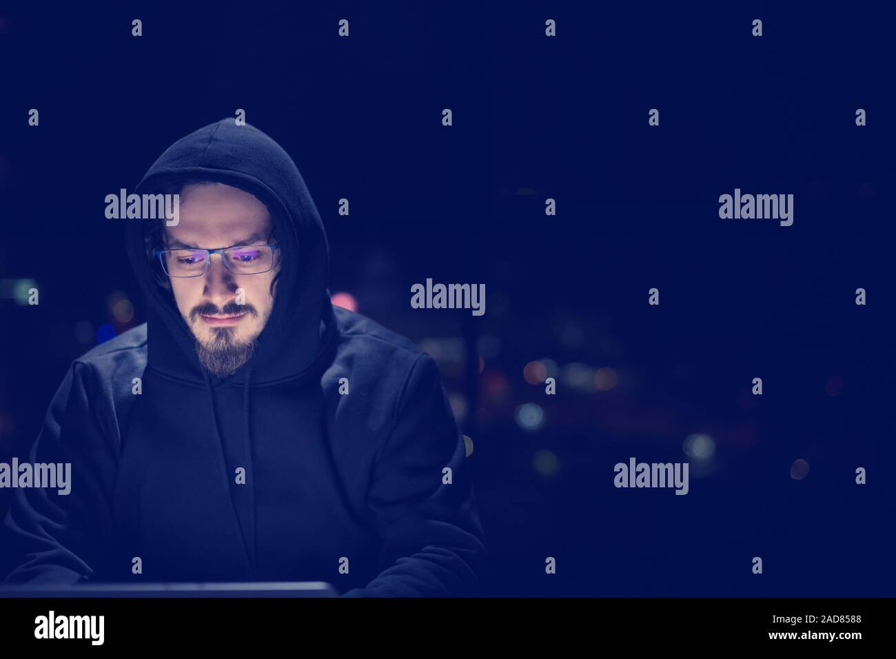 hacker using laptop computer while working in dark office Stock Photo ...
