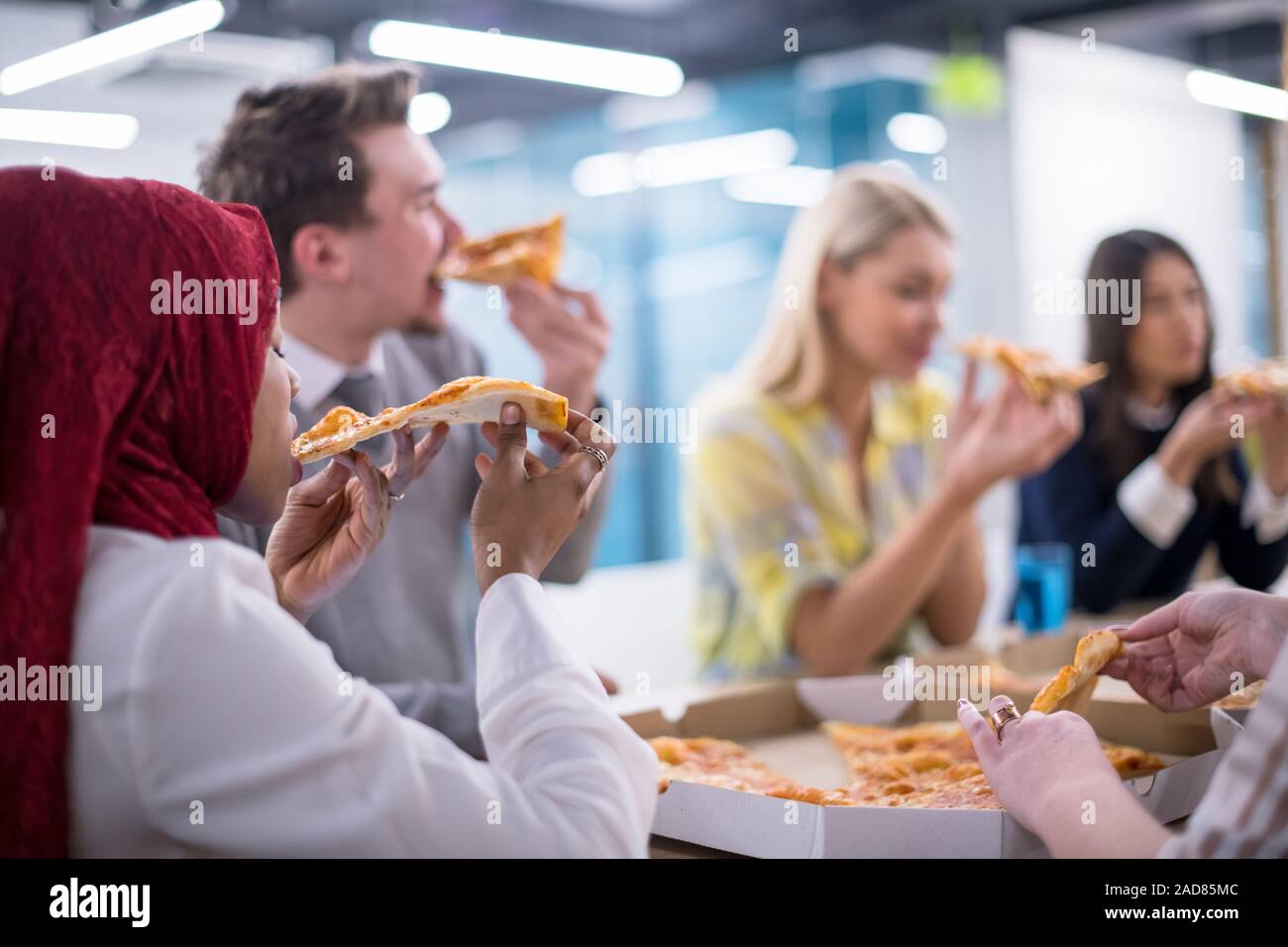 multiethnic business team eating pizza Stock Photo - Alamy