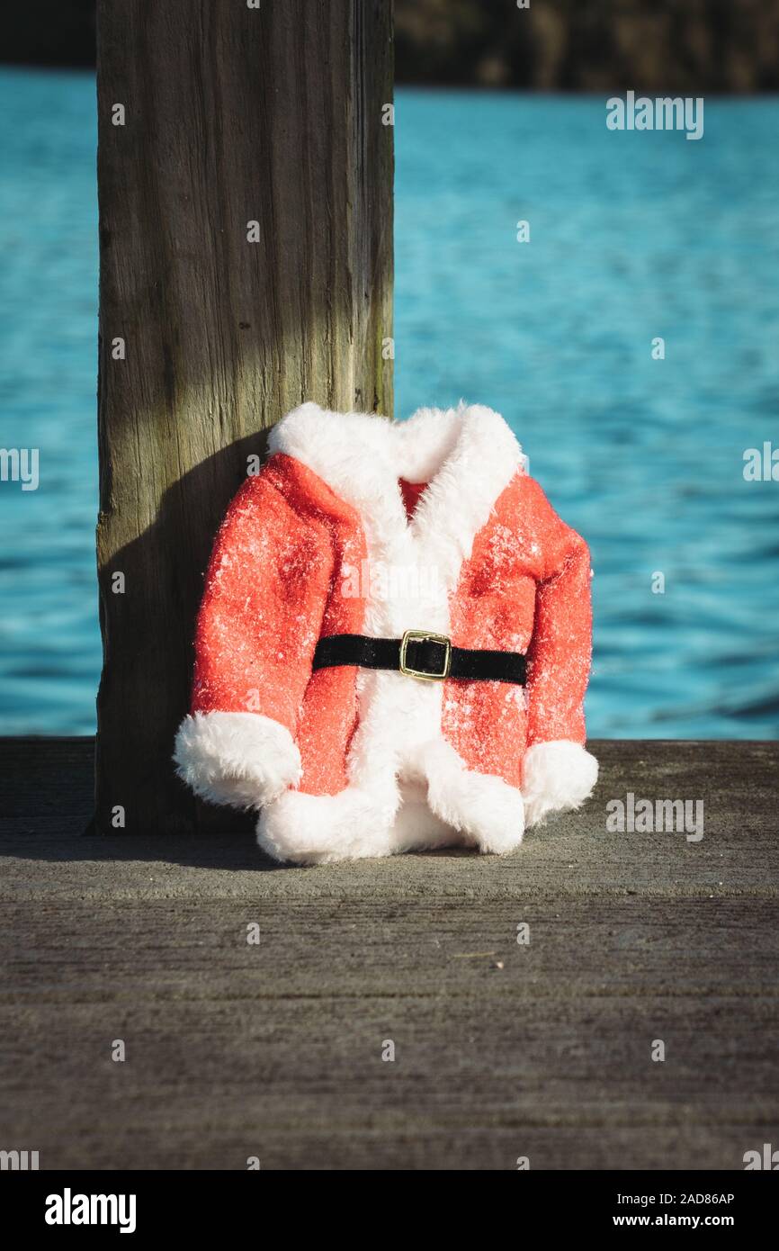 Christmas in Florida concept. Santa suit in the morning light on a lake ...