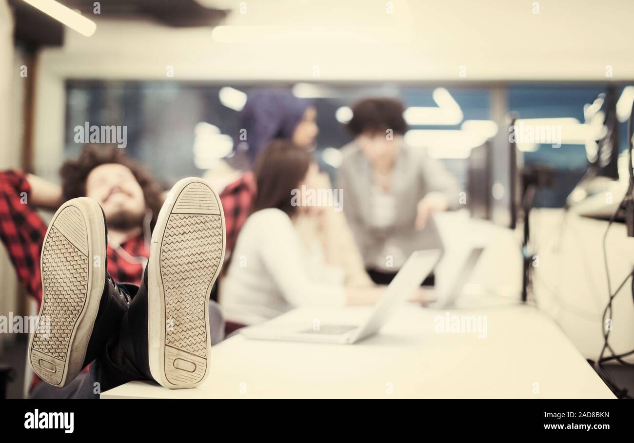 software developer resting with legs on desk Stock Photo - Alamy