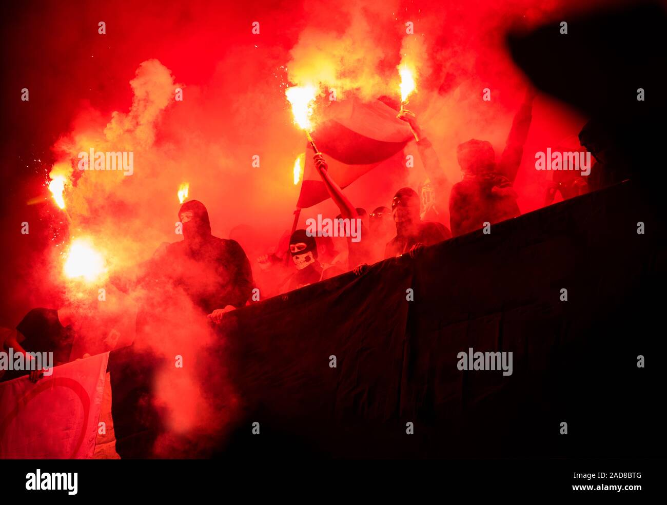 football hooligans with mask holding torches in fire Stock Photo - Alamy