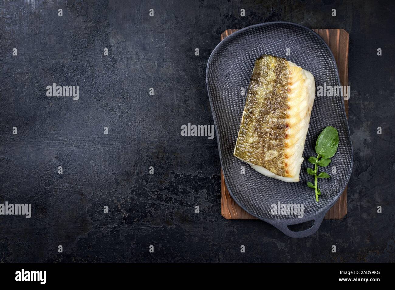 Fried Japanese skrei cod fish filet with wasabi lettuce as top view on ...