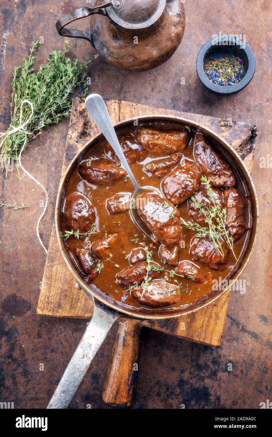 Traditional German braised pork cheeks in brown red wine sauce with ...