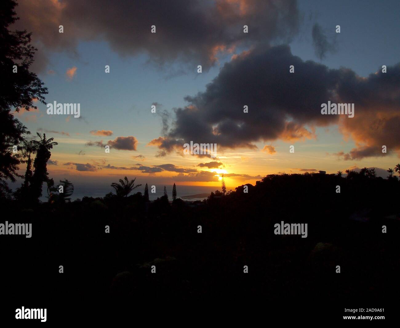 Sunset behind the clouds over the ocean on Tantalus mountain past ...