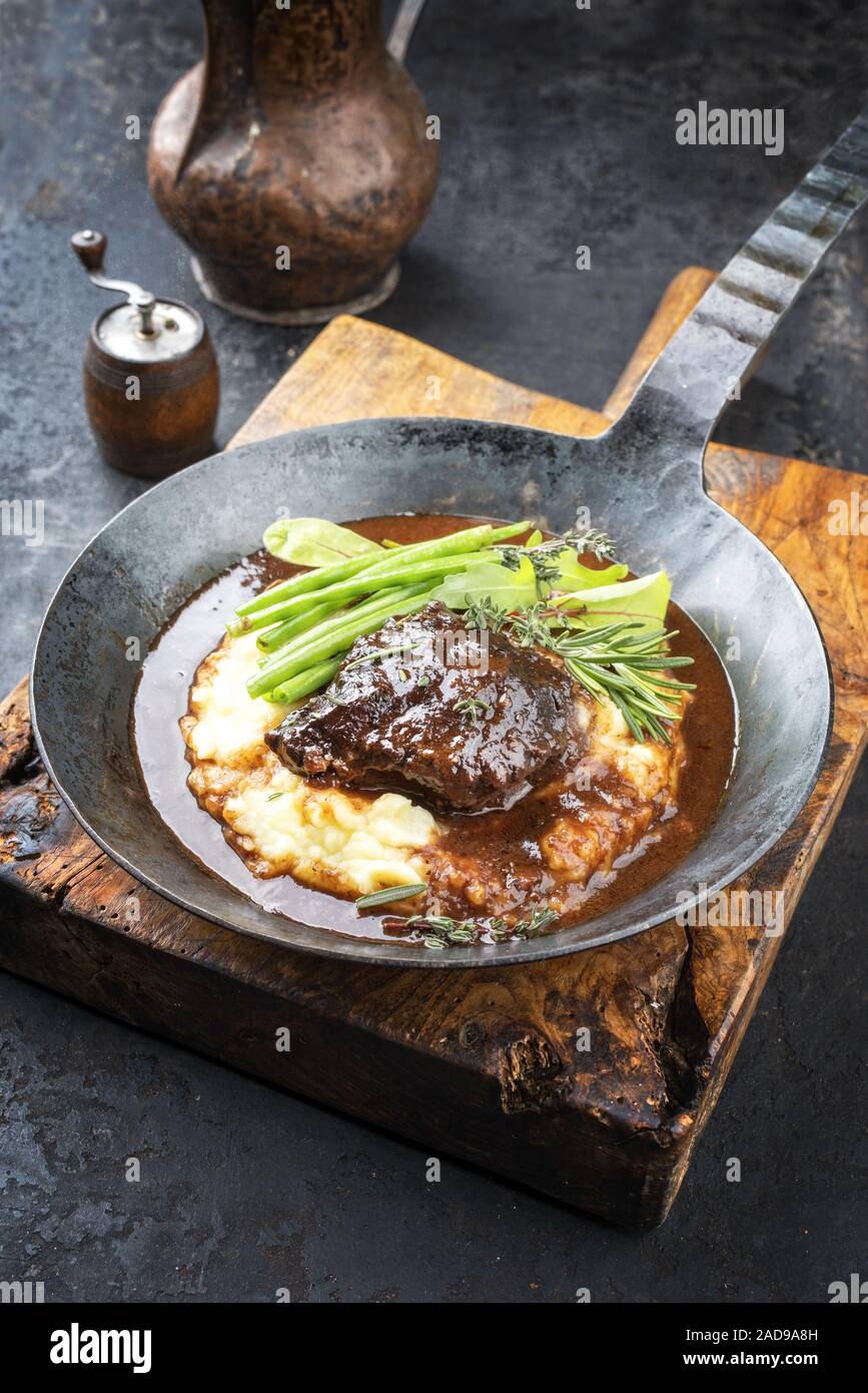 Traditional German braised veal cheeks in brown sauce with mashed ...