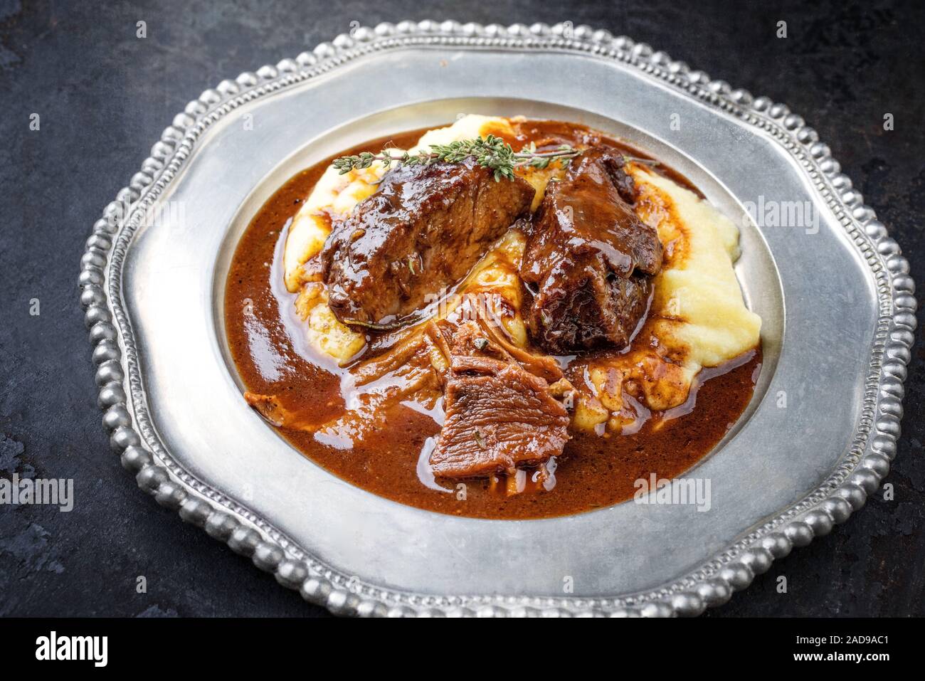 Traditional German braised veal cheeks in brown sauce with mashed ...