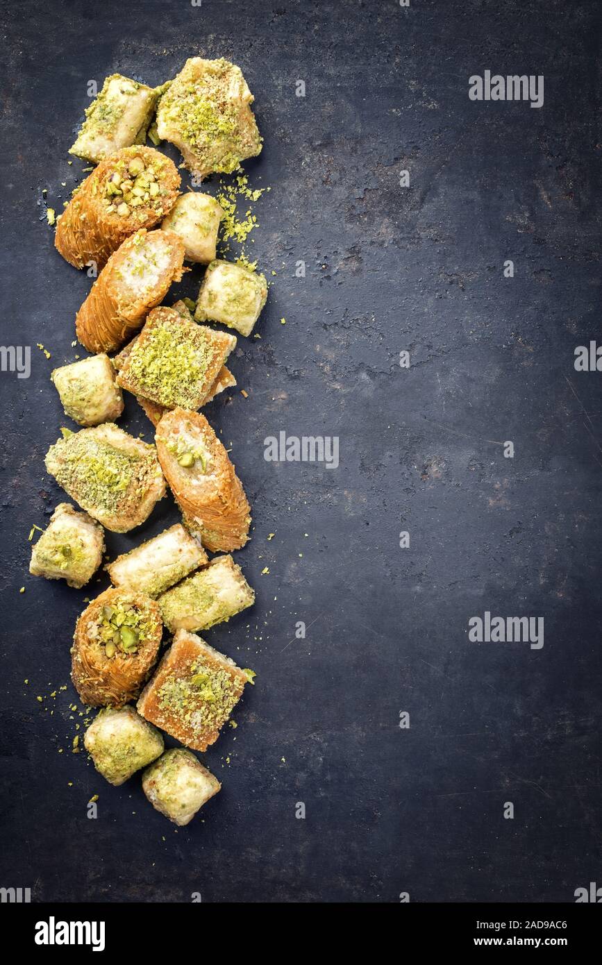 Traditional Oriental baklava collection as top view on a black board ...