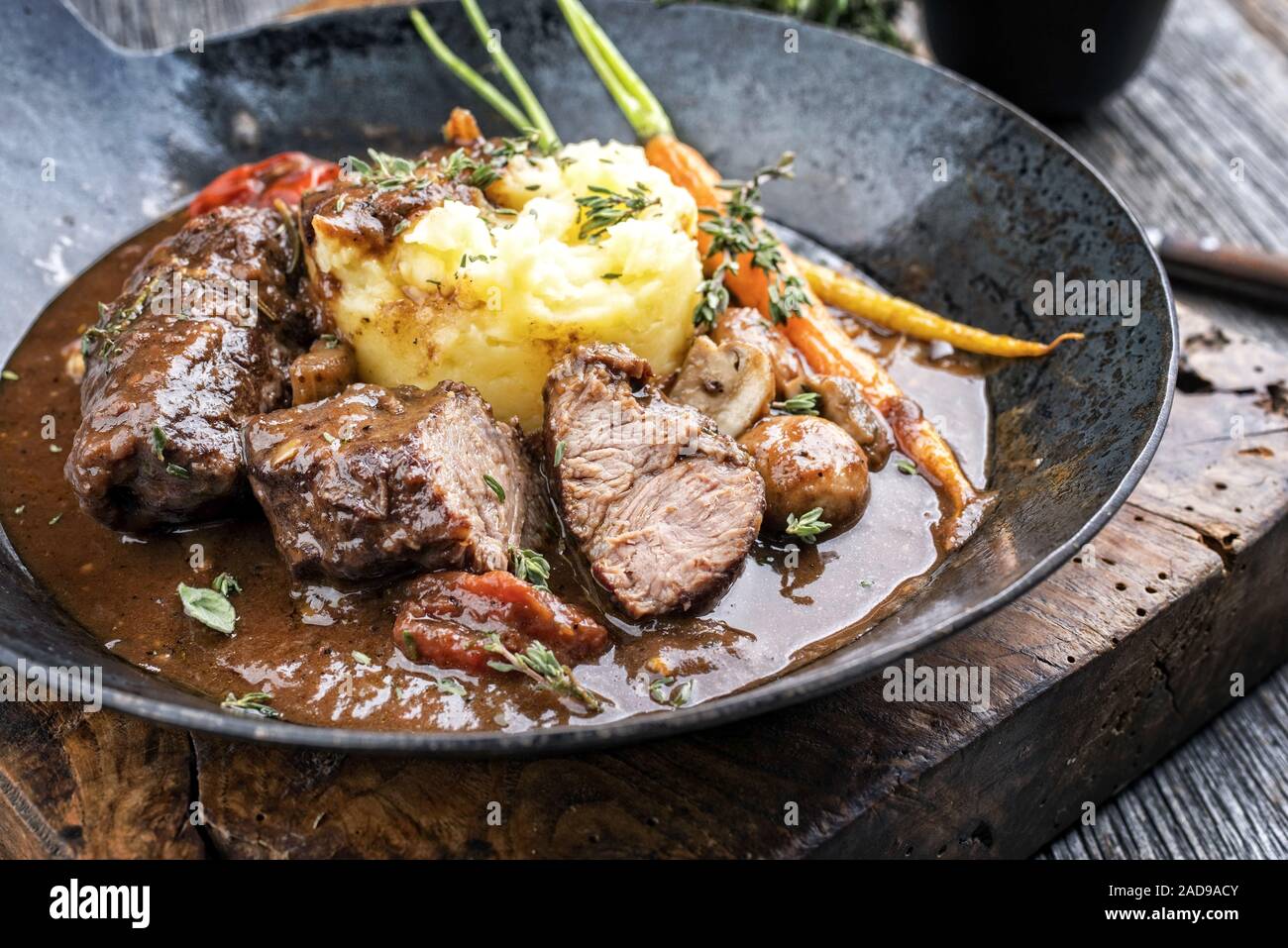 Traditional German braised pork cheeks in brown sauce with mushroom and ...
