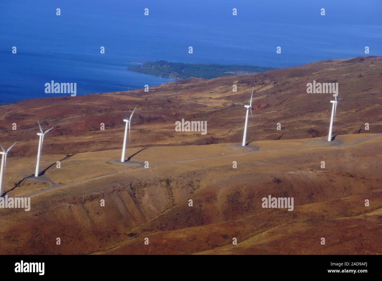 Aerial view of Modern Windmills spin on hillside with windy road and ...