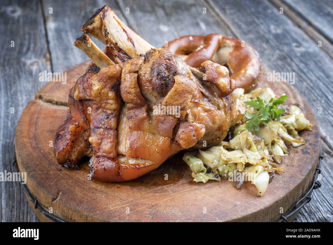 Traditional Bavarian schweinshaxe with coleslaw and preztel as closeup ...