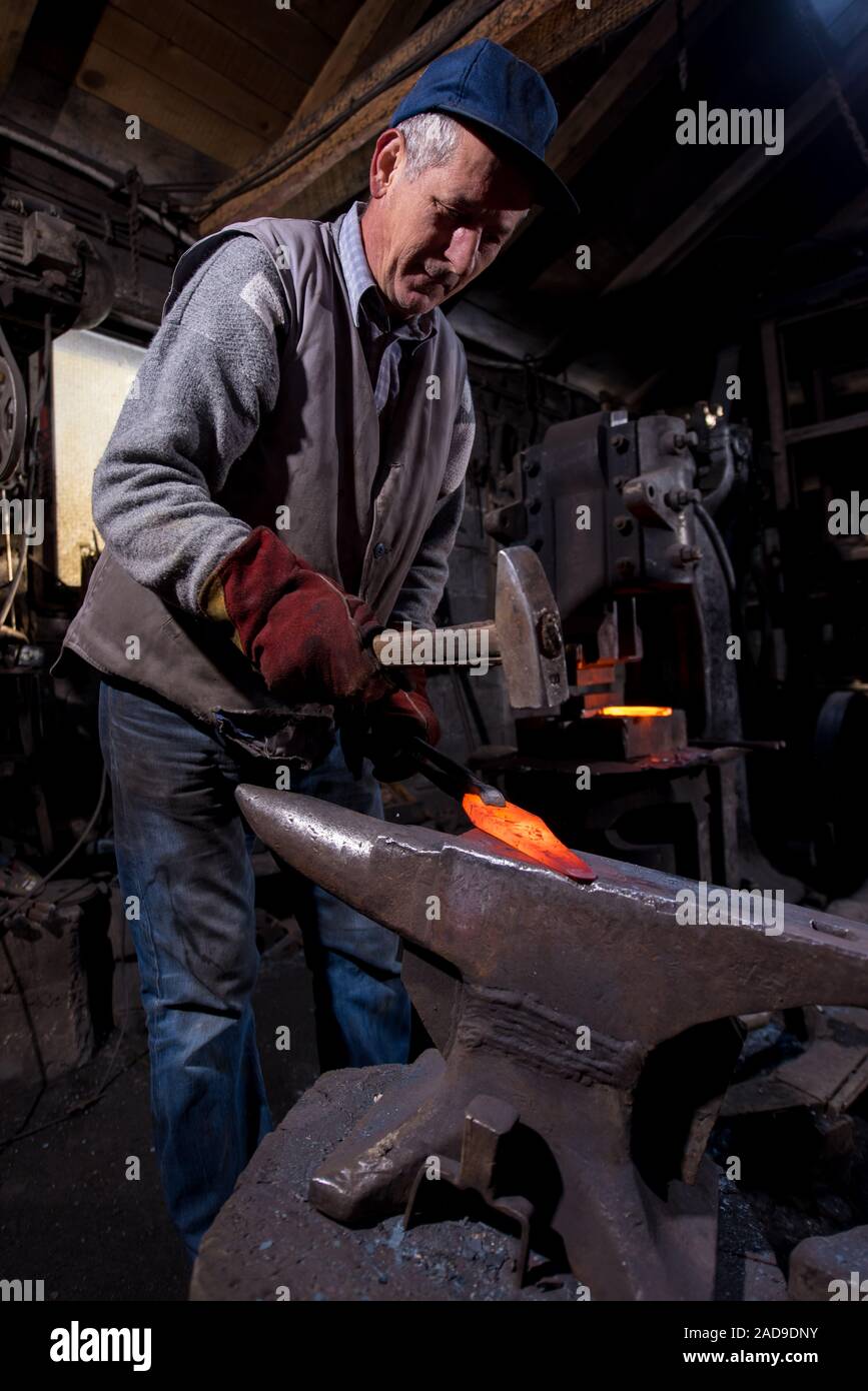 blacksmith manually forging the molten metal Stock Photo - Alamy