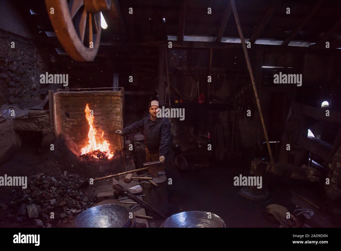 young traditional Blacksmith working with open fire Stock Photo - Alamy