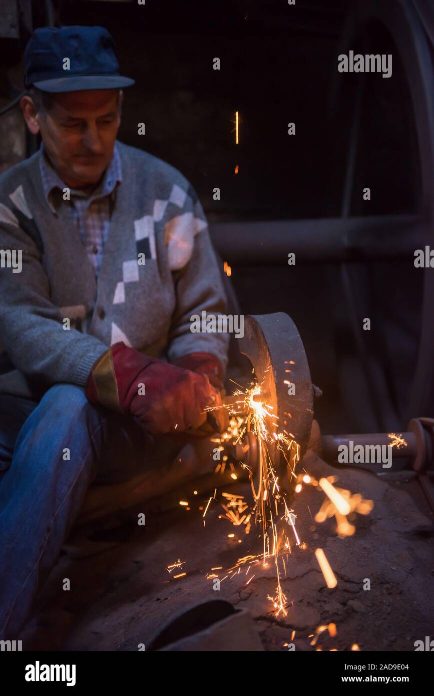 the blacksmith polishing metal products Stock Photo - Alamy