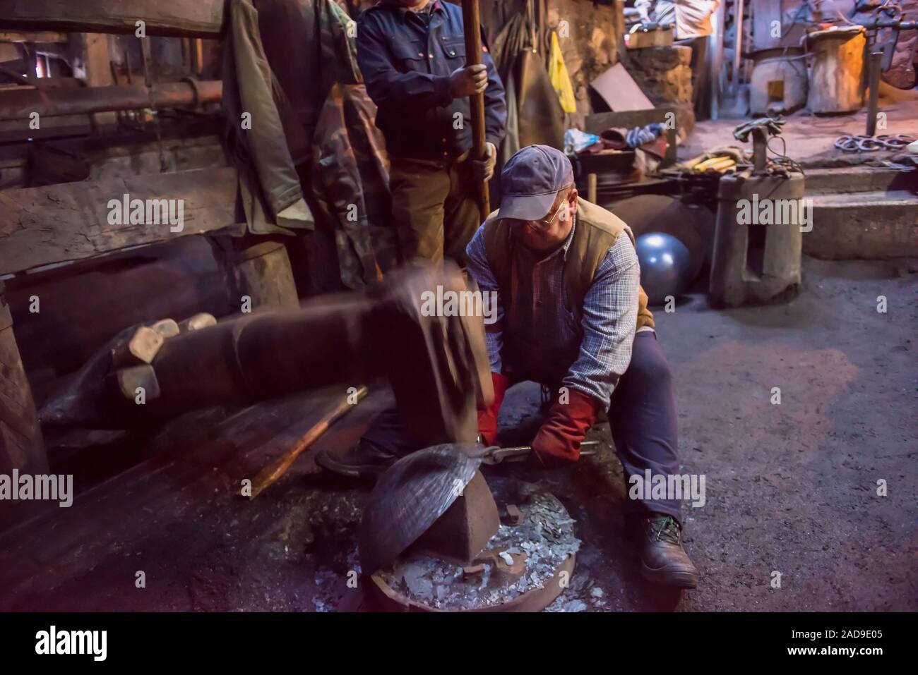 blacksmith workers using mechanical hammer at workshop Stock Photo - Alamy
