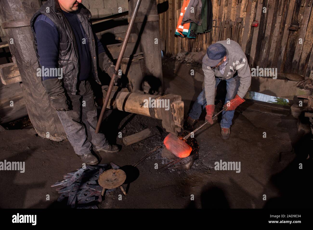 blacksmith workers using mechanical hammer at workshop Stock Photo - Alamy