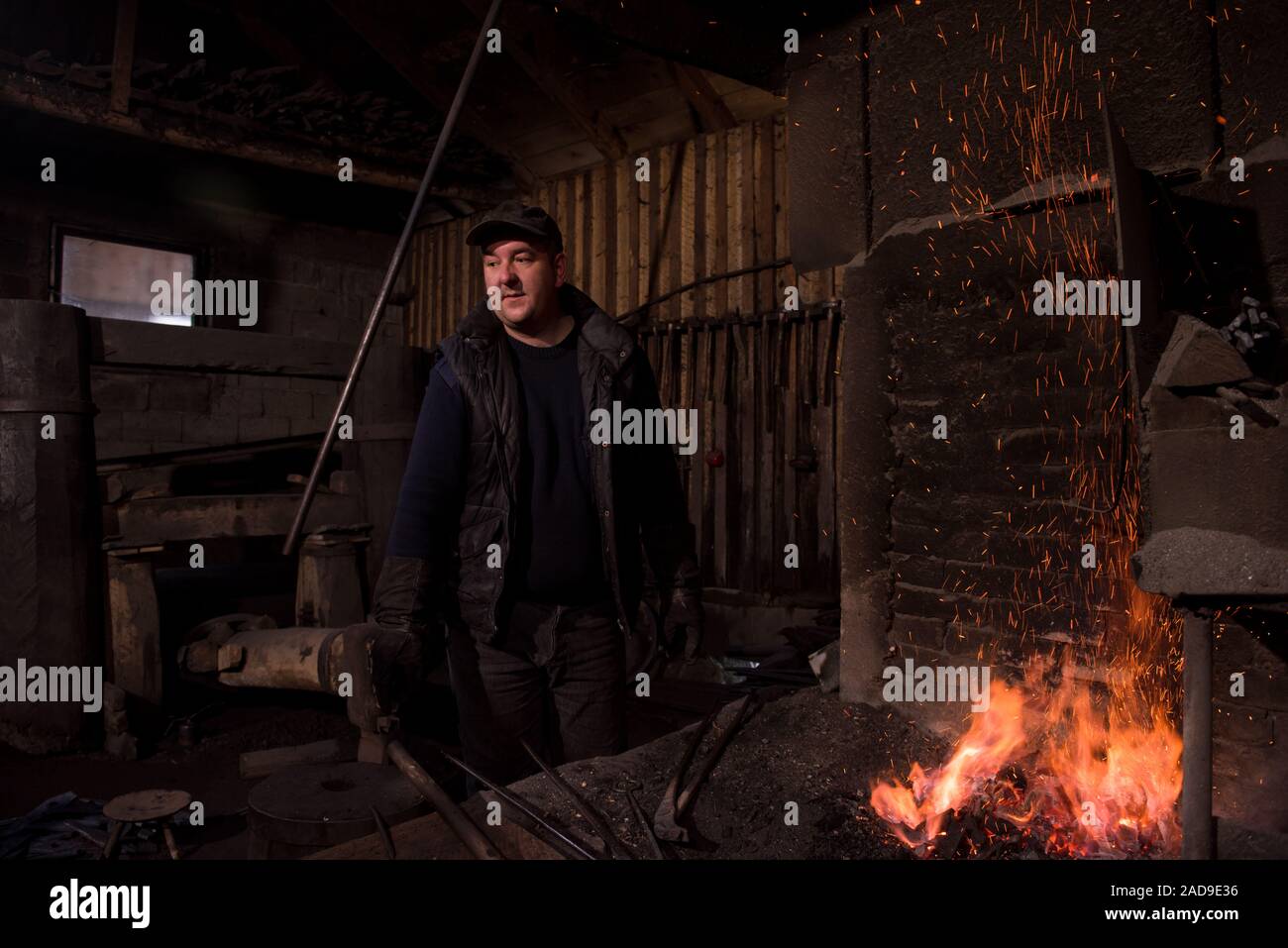 young traditional Blacksmith working with open fire Stock Photo - Alamy