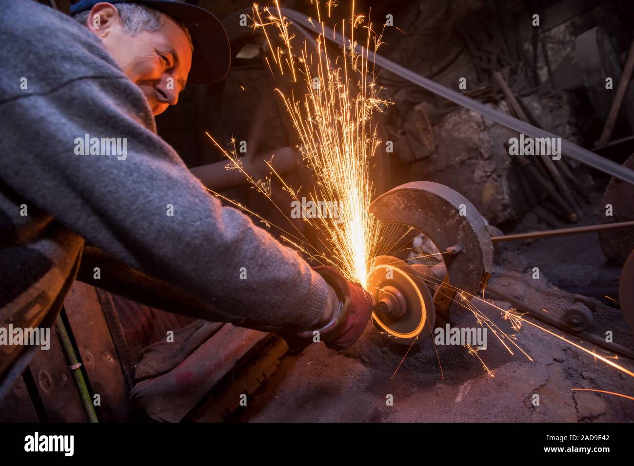 the blacksmith polishing metal products Stock Photo - Alamy