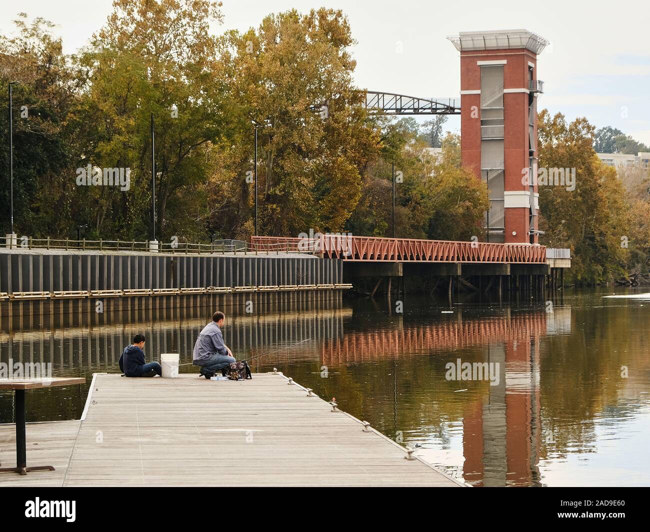 Father and son or man and boy fishing on a dock on the Alabama River in ...