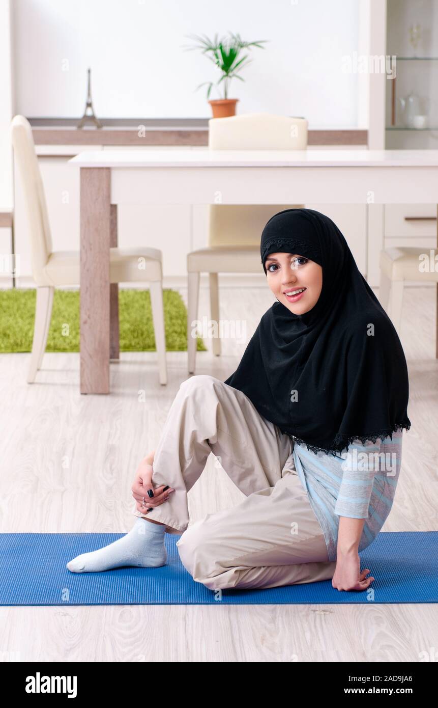 Young woman in hijab doing exercises at home Stock Photo - Alamy