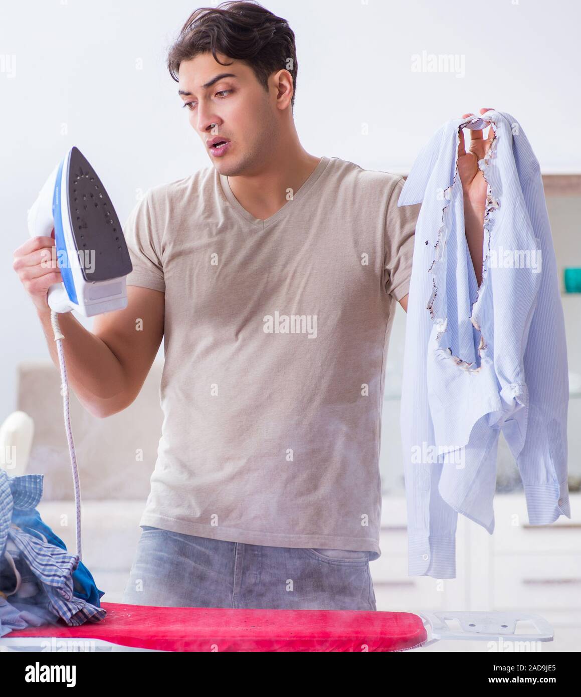 Inattentive husband burning clothing while ironing Stock Photo - Alamy