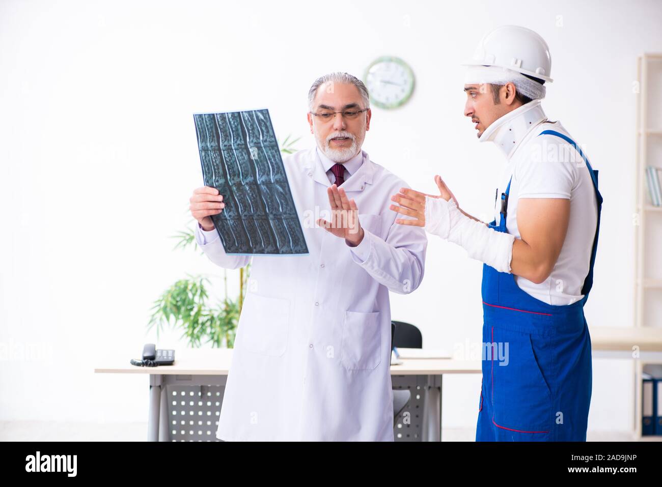 Young male contractor visiting old doctor Stock Photo - Alamy