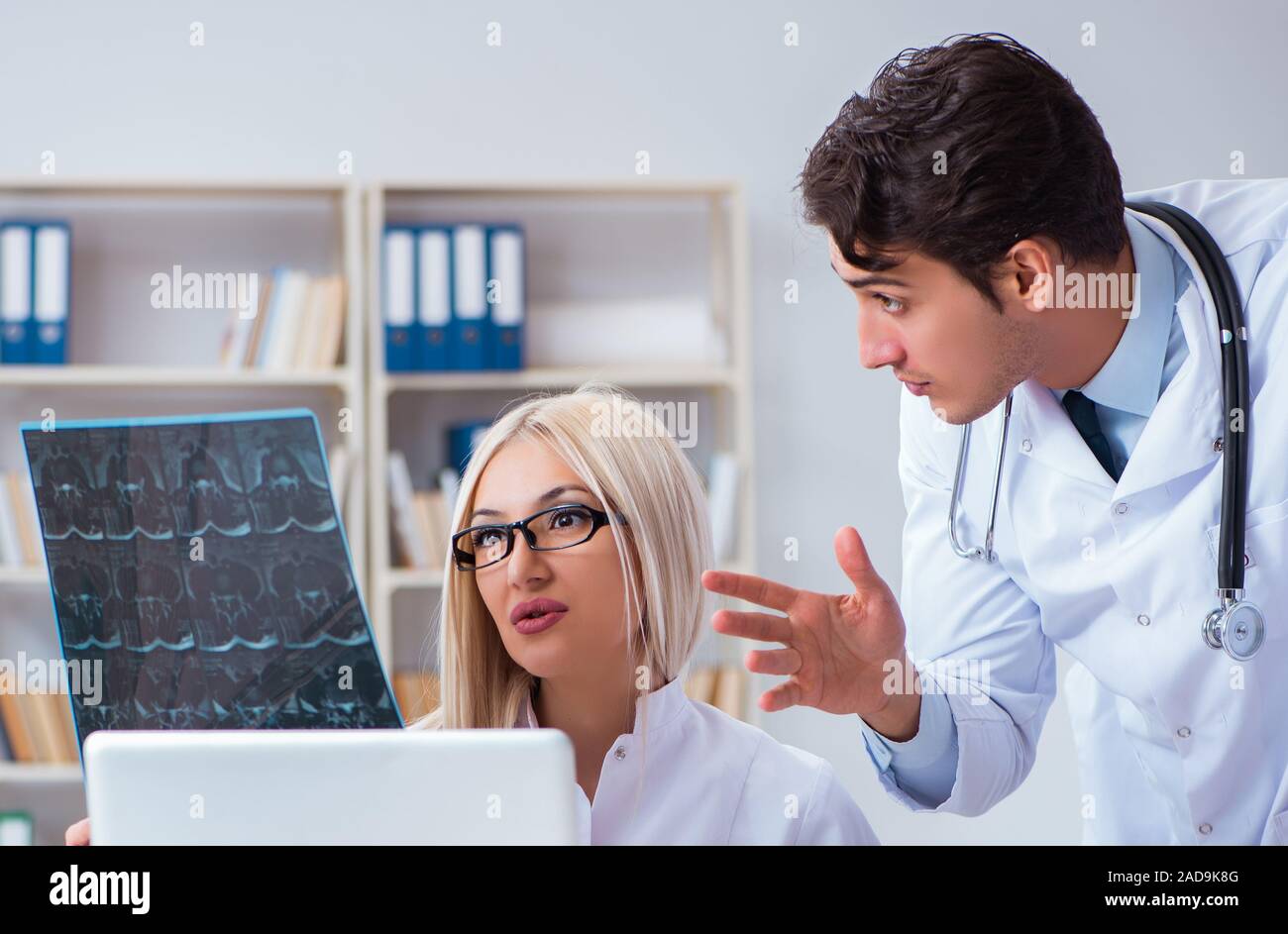Two doctors examining x-ray images of patient for diagnosis Stock Photo ...