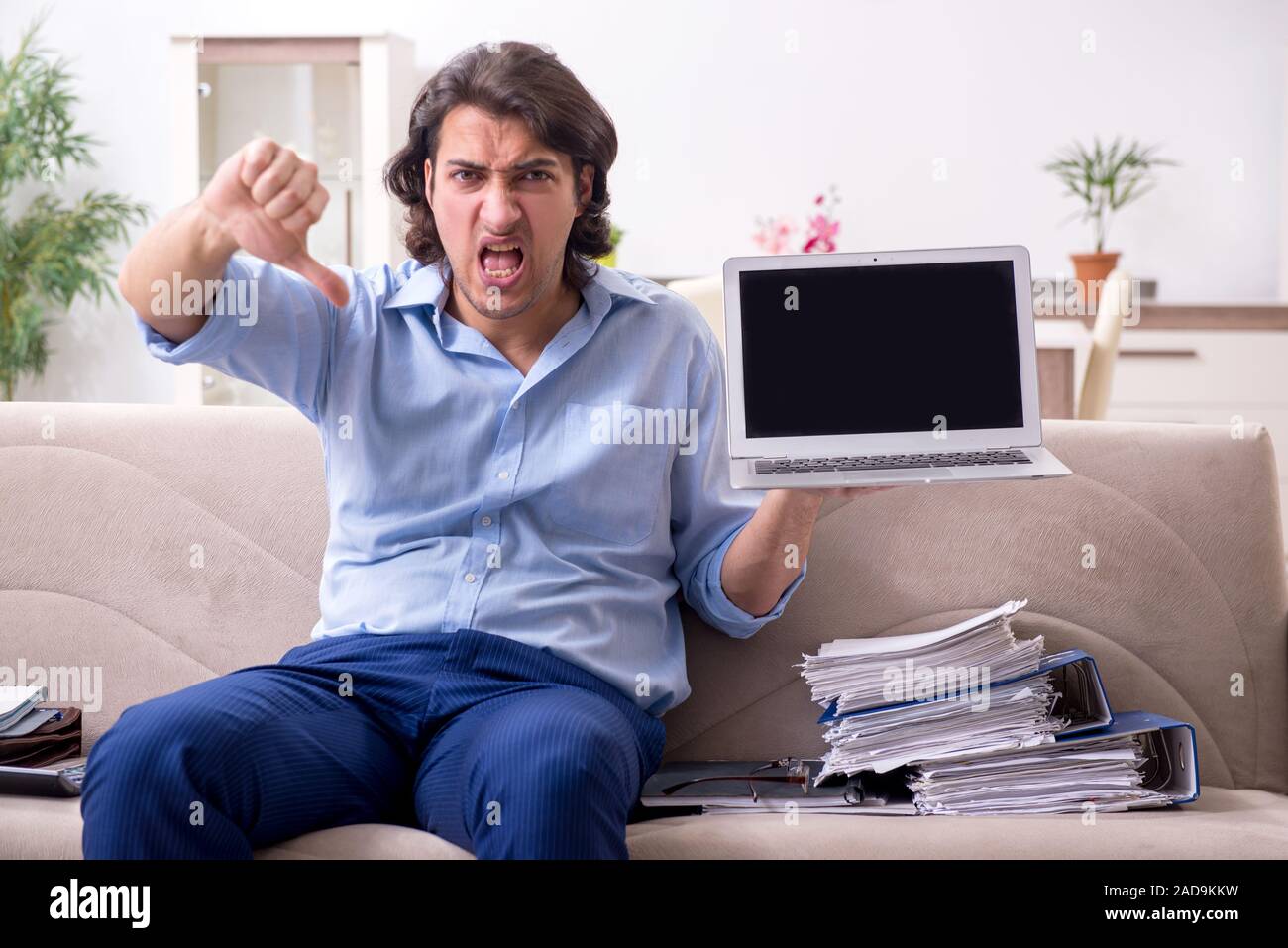 Young male employee working at home Stock Photo - Alamy