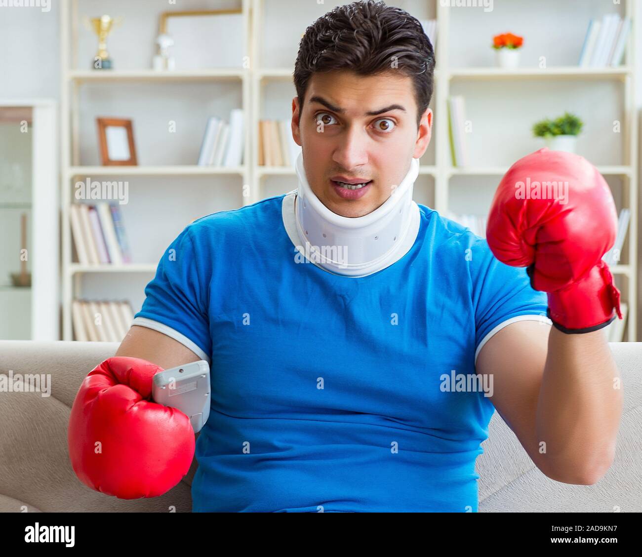 Man with neck injury watching boxing at home Stock Photo - Alamy