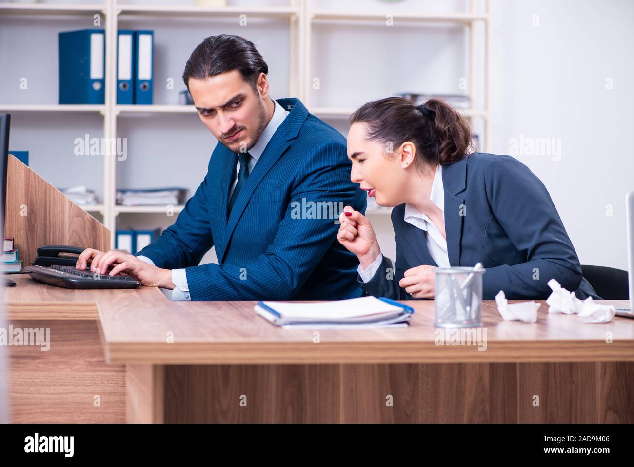 Two employees suffering at workplace Stock Photo - Alamy