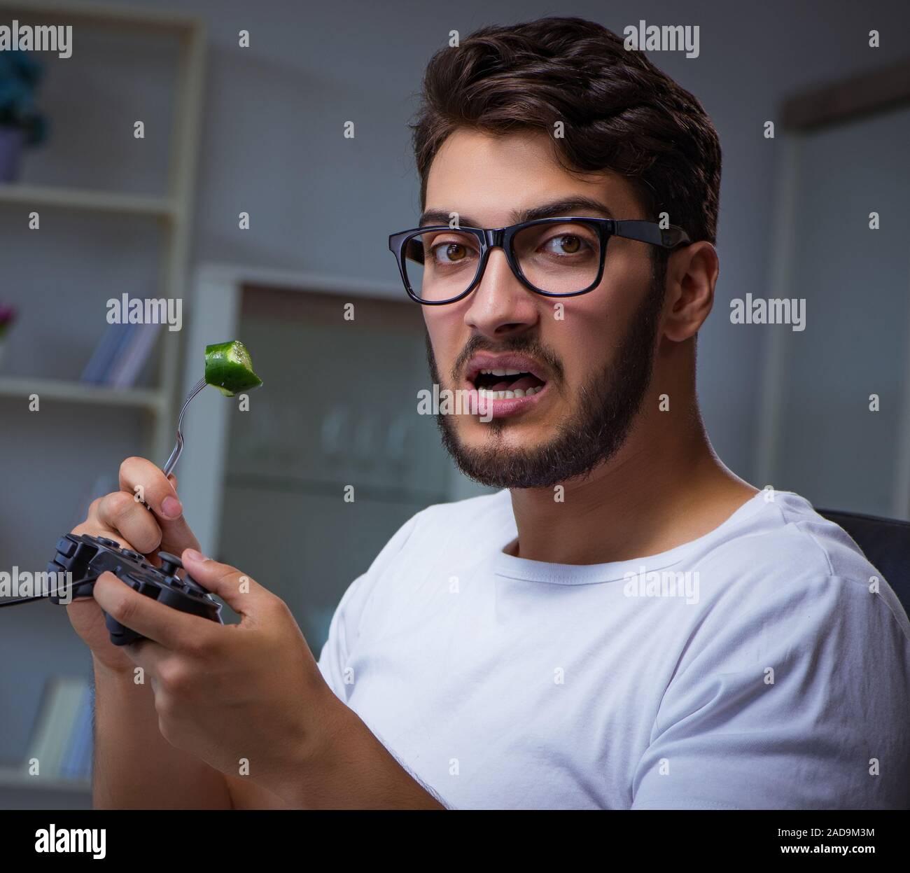 Young man playing games long hours late in the office Stock Photo - Alamy