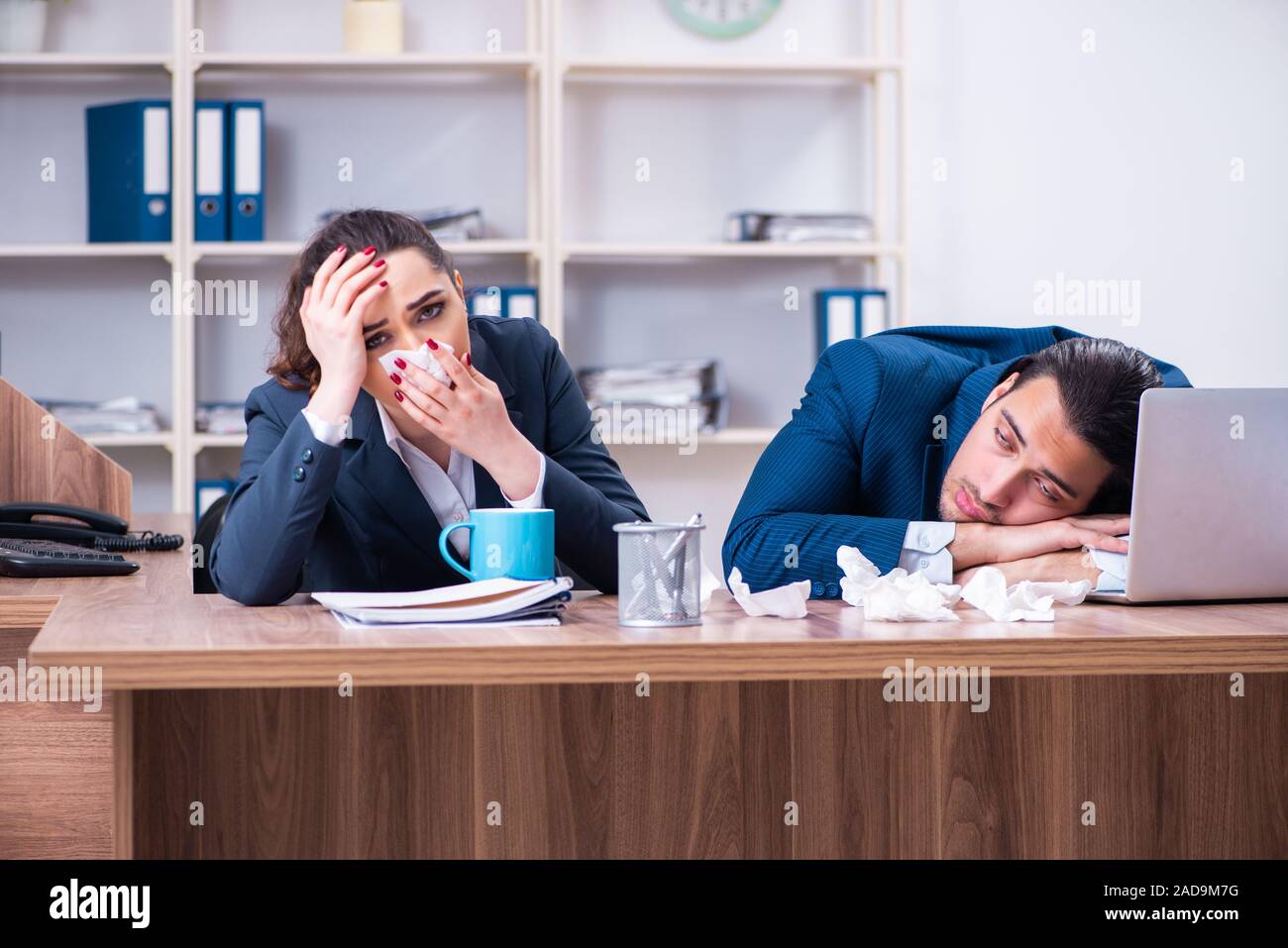 Two employees suffering at workplace Stock Photo - Alamy