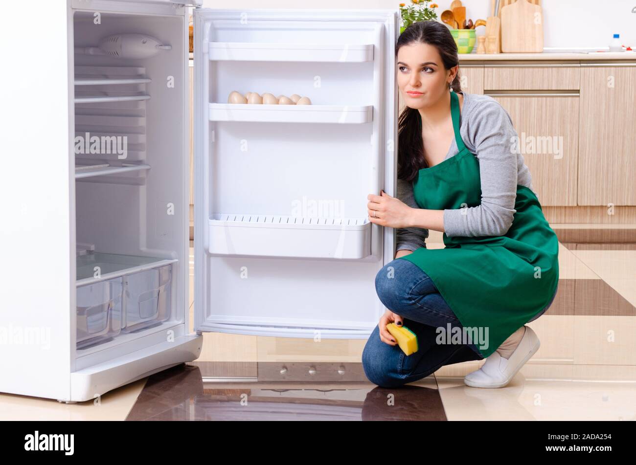 Young woman cleaning fridge in hygiene concept Stock Photo - Alamy