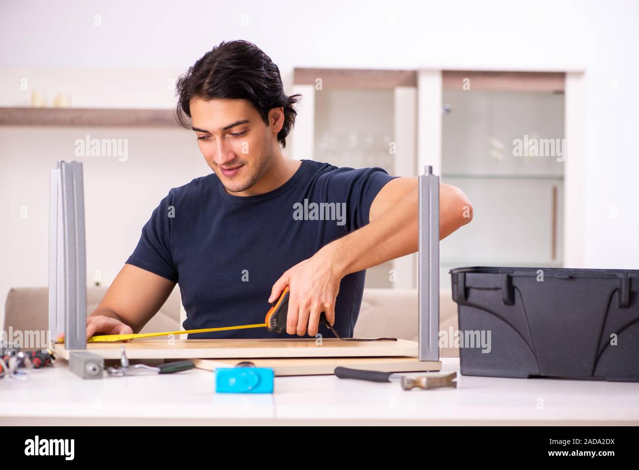 Young man repairing furniture at home Stock Photo - Alamy