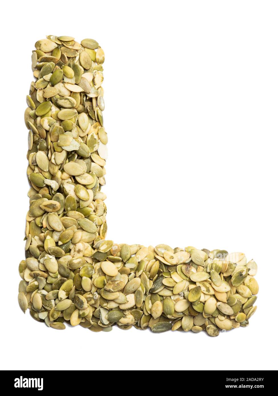 Letter L of the English alphabet from pumpkin seeds on a white isolated ...