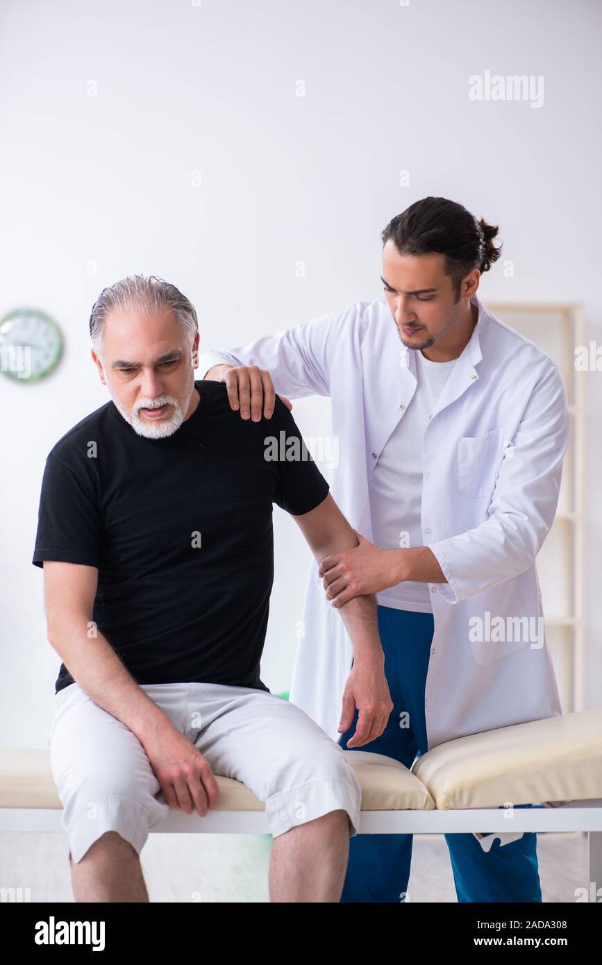 Old injured man visiting young doctor Stock Photo - Alamy