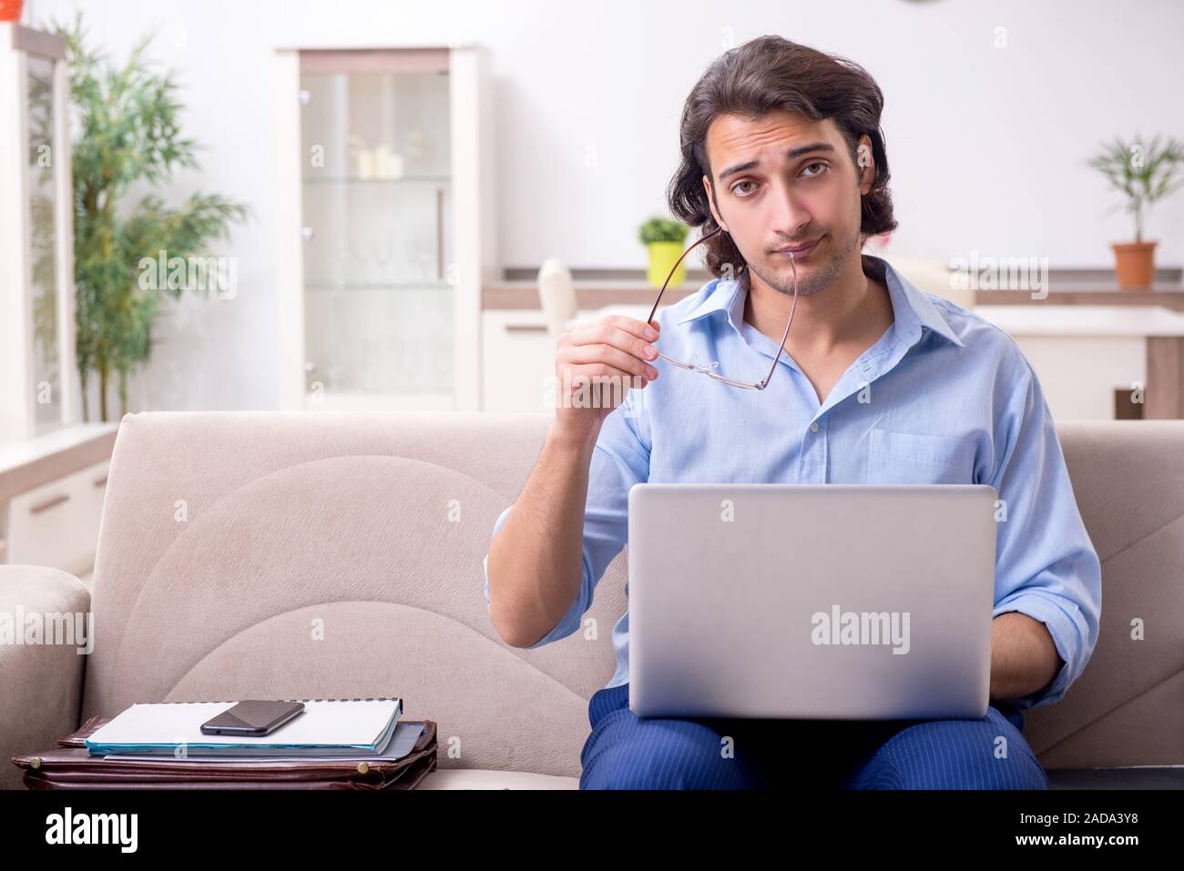 Young male employee working at home Stock Photo - Alamy