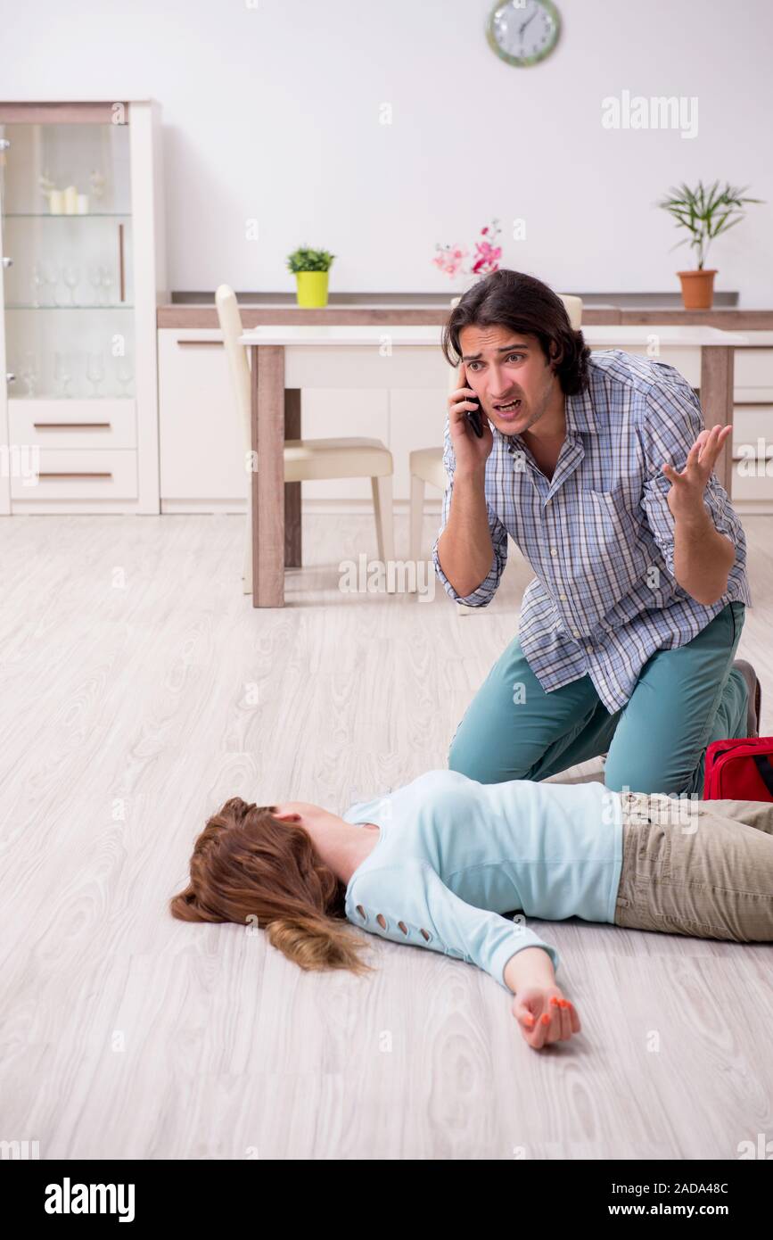 Young couple in first aid concept at home Stock Photo - Alamy