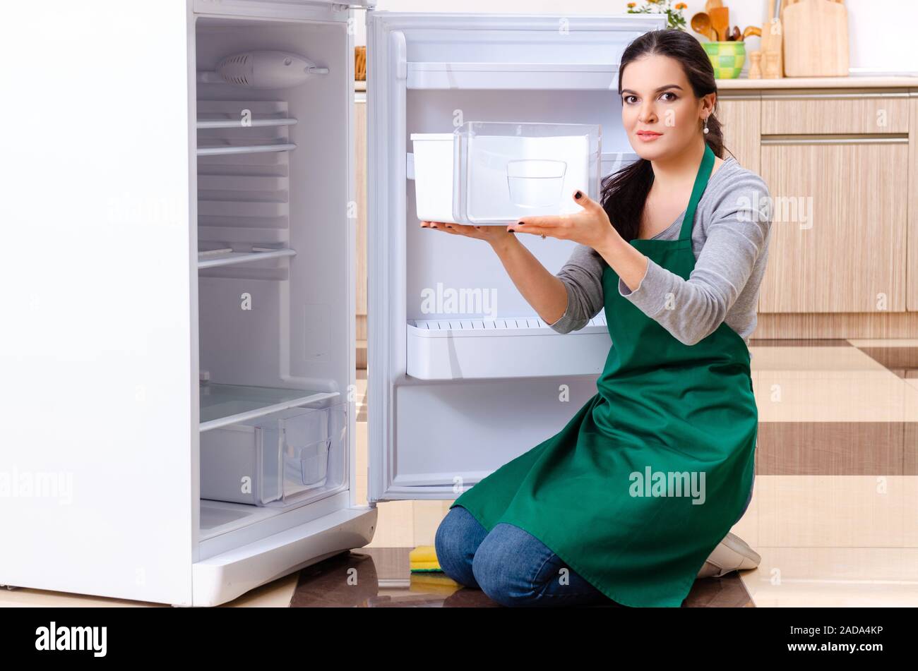 Young woman cleaning fridge in hygiene concept Stock Photo - Alamy