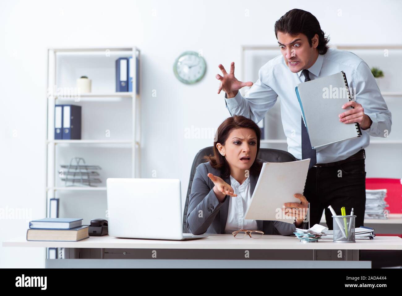 Old female boss and young male employee in the office Stock Photo - Alamy